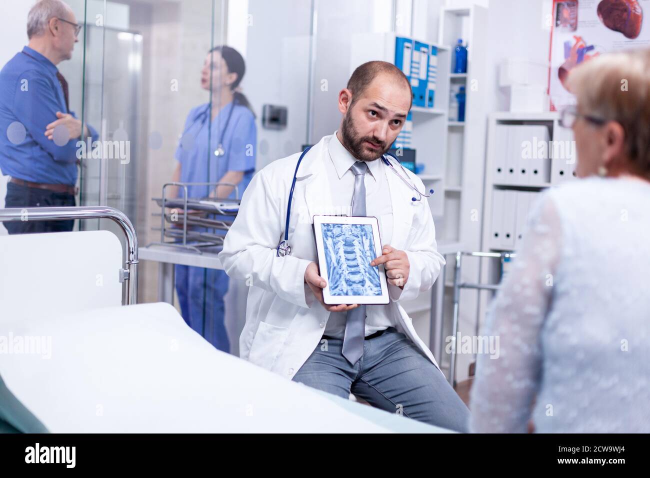 Doctor showing radiology scan to senior patient after medical check in ...