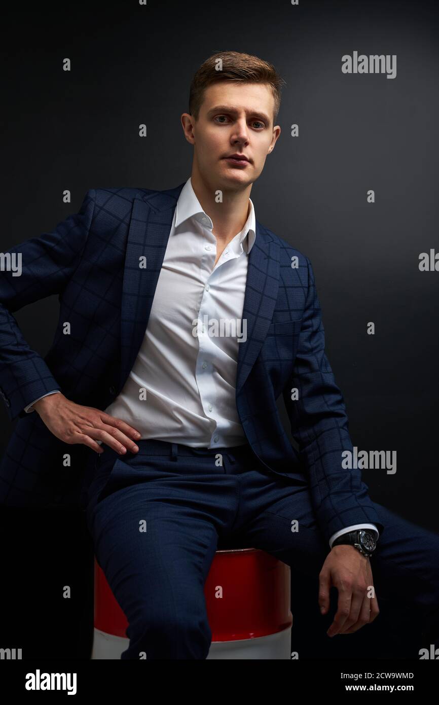 young influential oil tycoon sits on oil barrel isolated over black ...