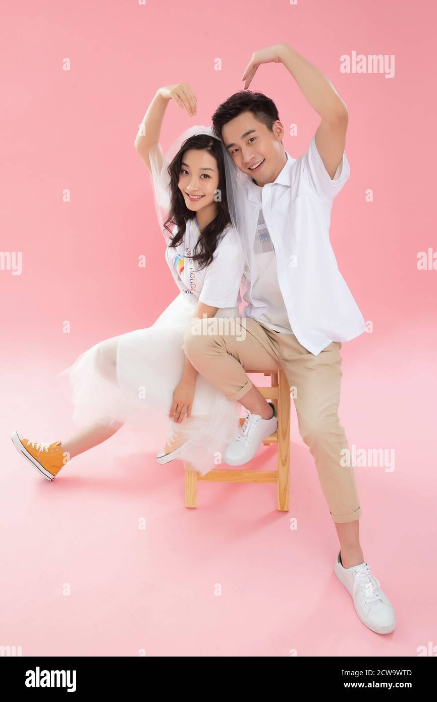 Happy couples do heart shape on the bed Stock Photo - Alamy