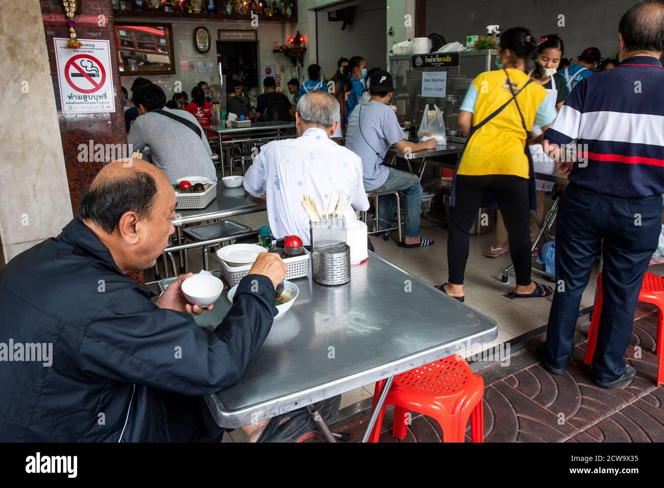Customers getting food and eating in small restaurant in Bangkok's ...