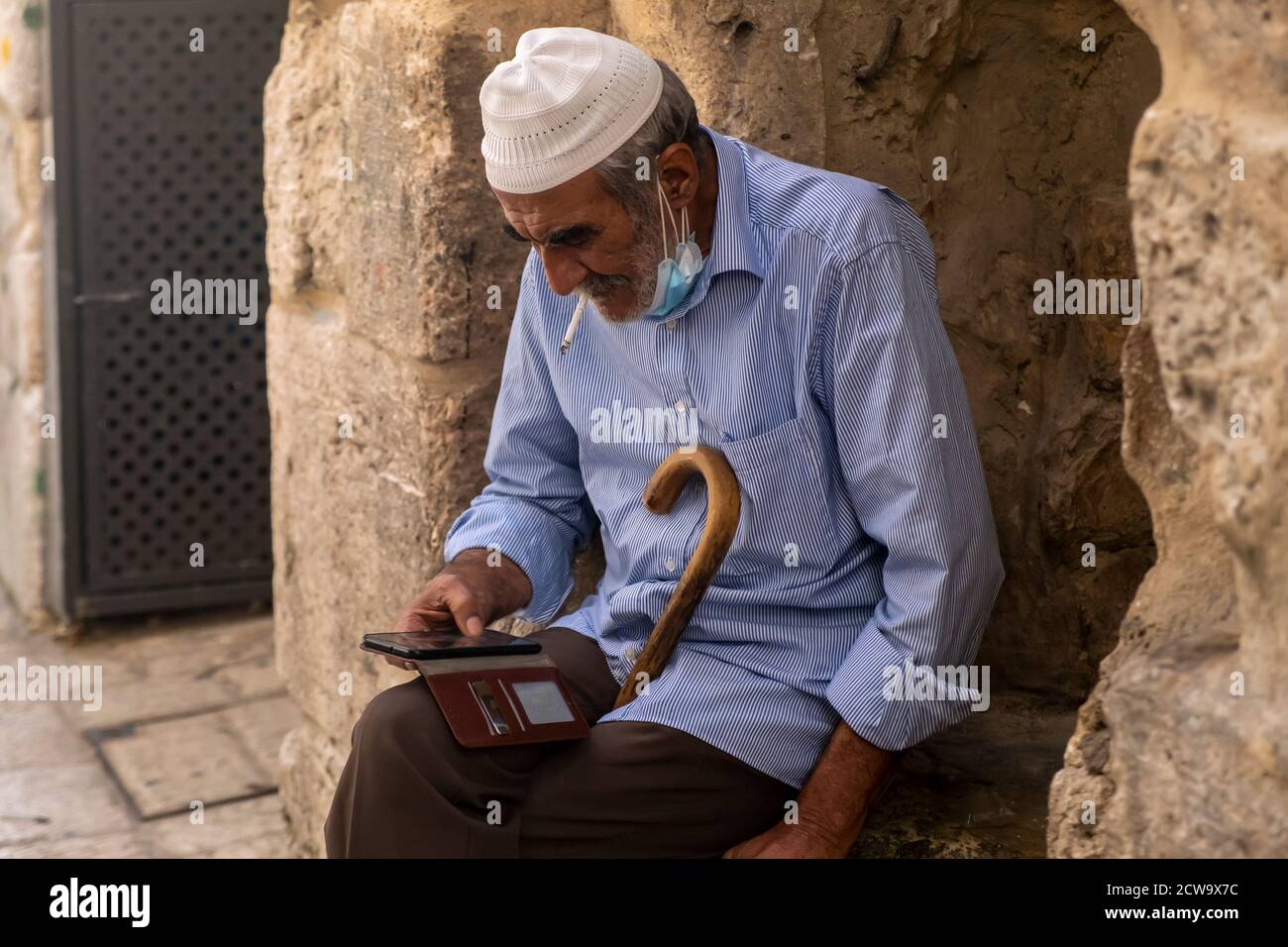 An elderly Palestinian man using a cell phone in the old city East ...