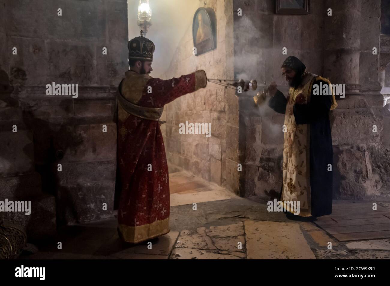 A Coptic Orthodox and Armenian priest censing with thurible inside the ...