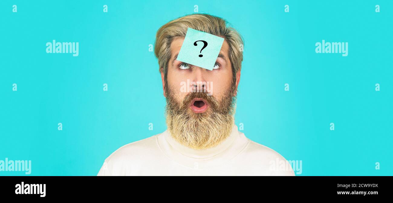 Man with question mark on forehead looking up. Paper notes with ...