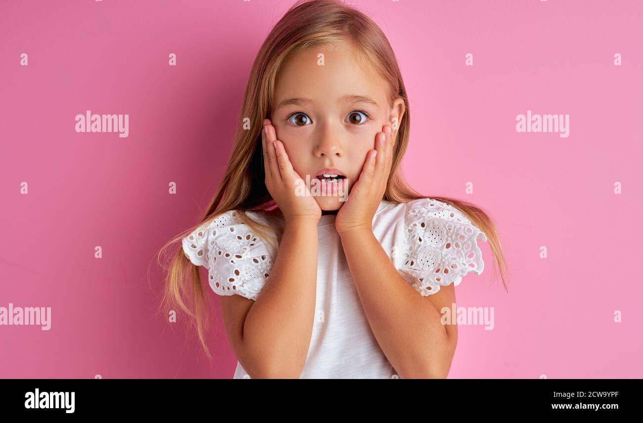 portrait of little caucasian girl in shock, she is surprised by ...