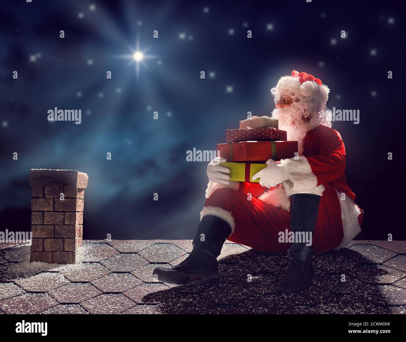 Merry Christmas and happy holidays! Santa Claus sitting on the roof of ...