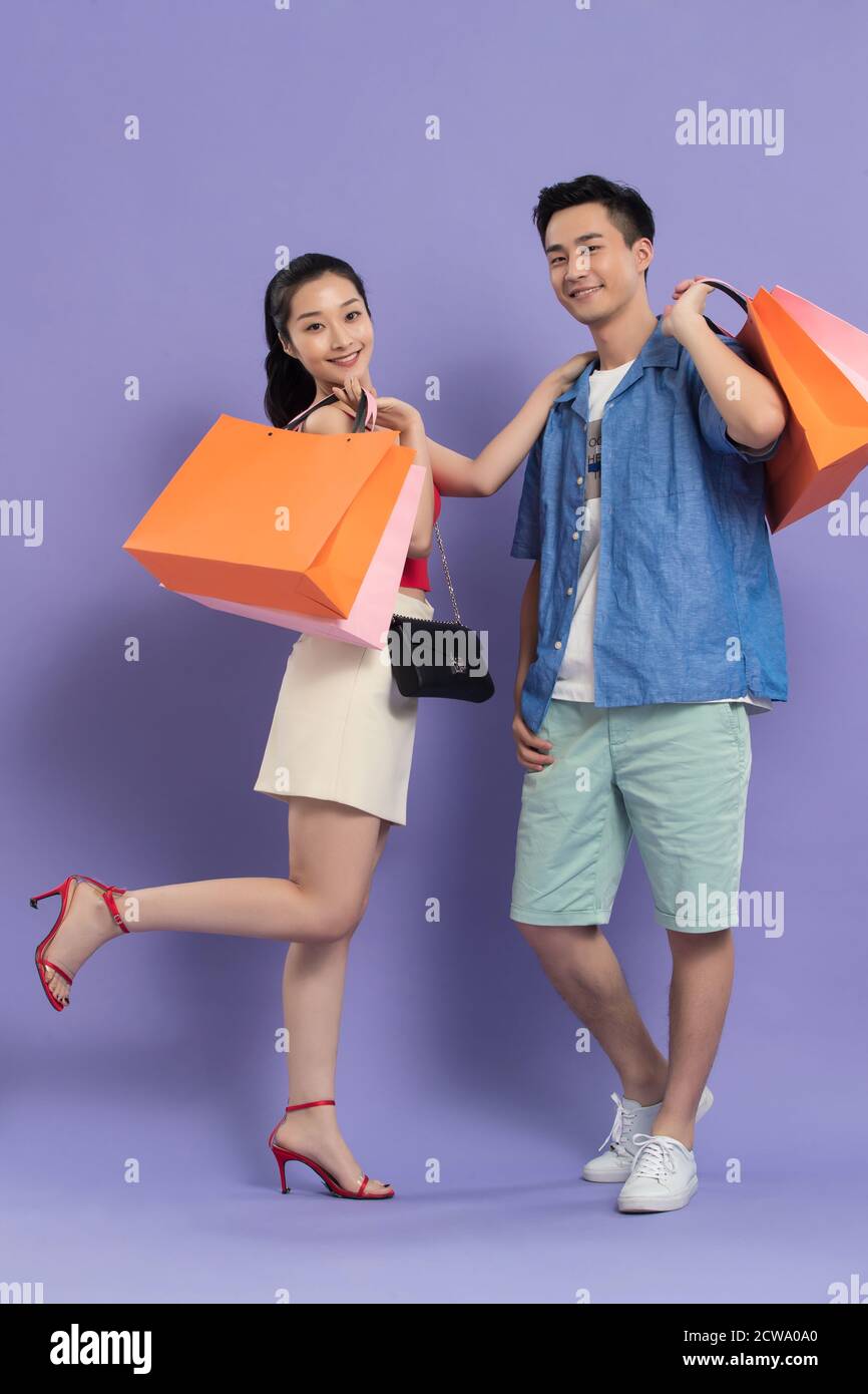 Carrying shopping bags of happy young partner Stock Photo - Alamy