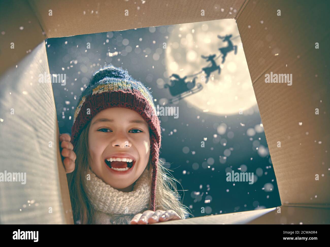 Merry Christmas and happy holidays! Cheerful cute child girl opening a ...