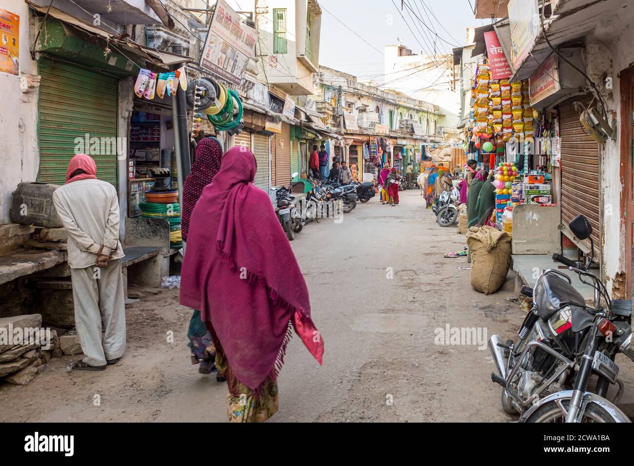 Locals walking down the narrow streets of Delwara village, near Udaipur ...