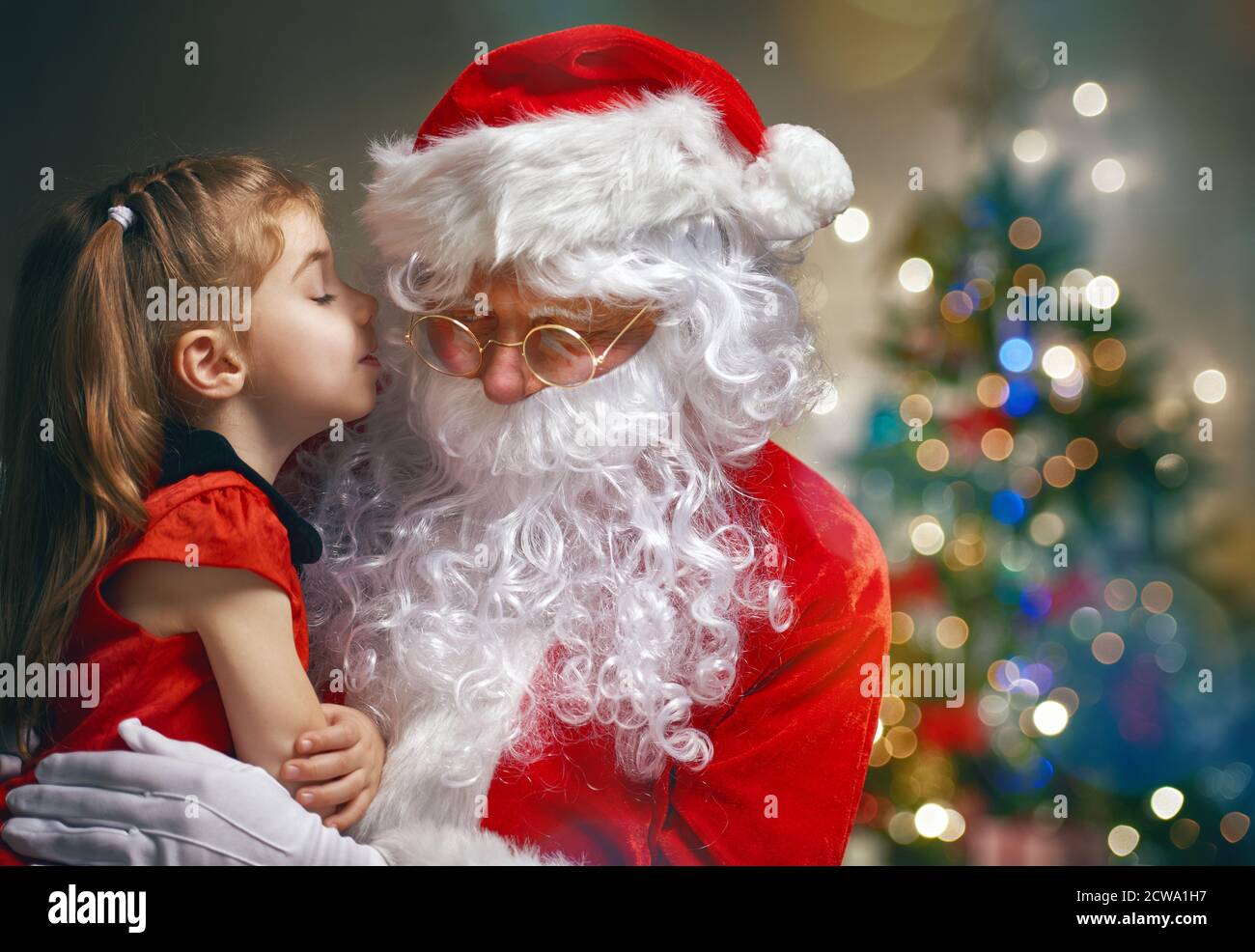 Santa listening to a little girl's wishes Stock Photo - Alamy