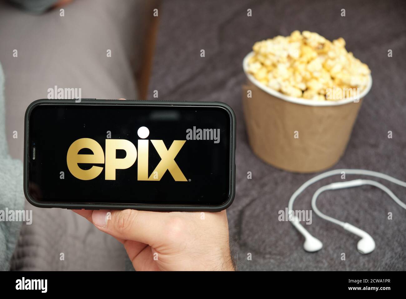 Epix logo on the smartphone screen with popcorn box and Apple earpods ...
