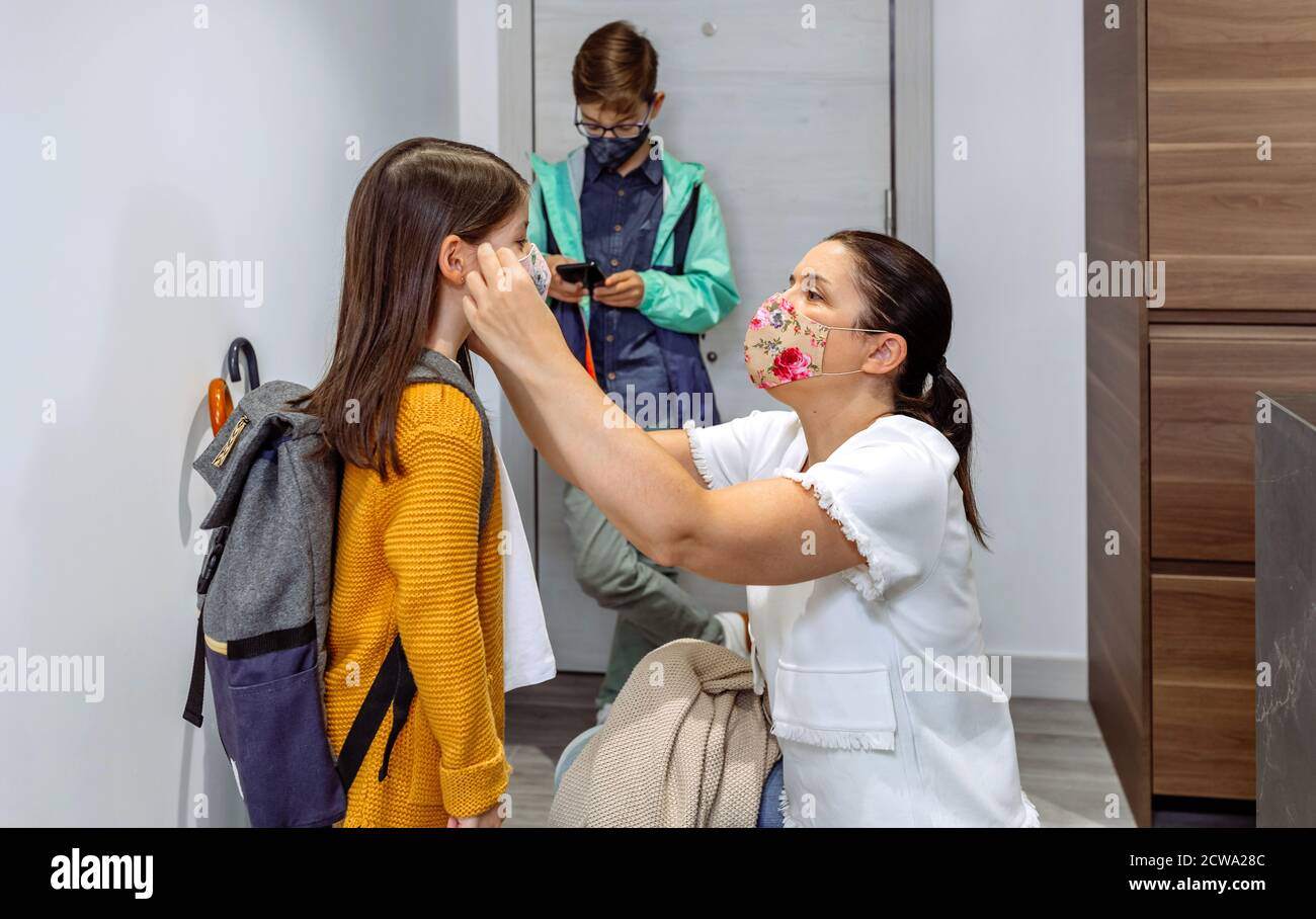 Mother putting the mask on her daughter Stock Photo - Alamy