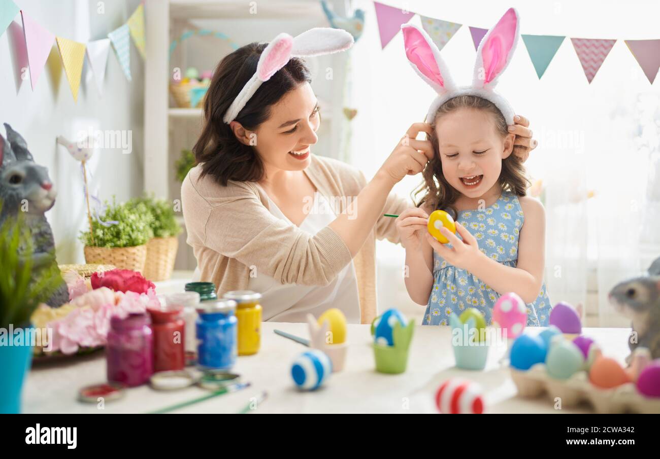 Happy easter! A mother and her daughter painting Easter eggs. Happy ...