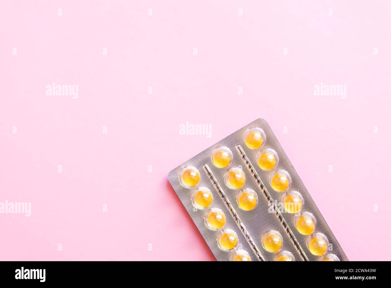 Vitamins pink in the package on a soft pink background Stock Photo - Alamy