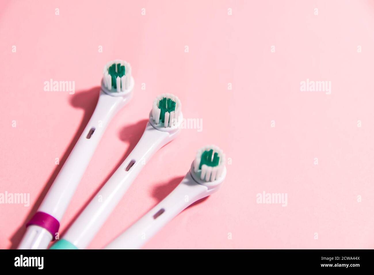 Two electrical toothbrushes on a soft light pink background Stock Photo ...