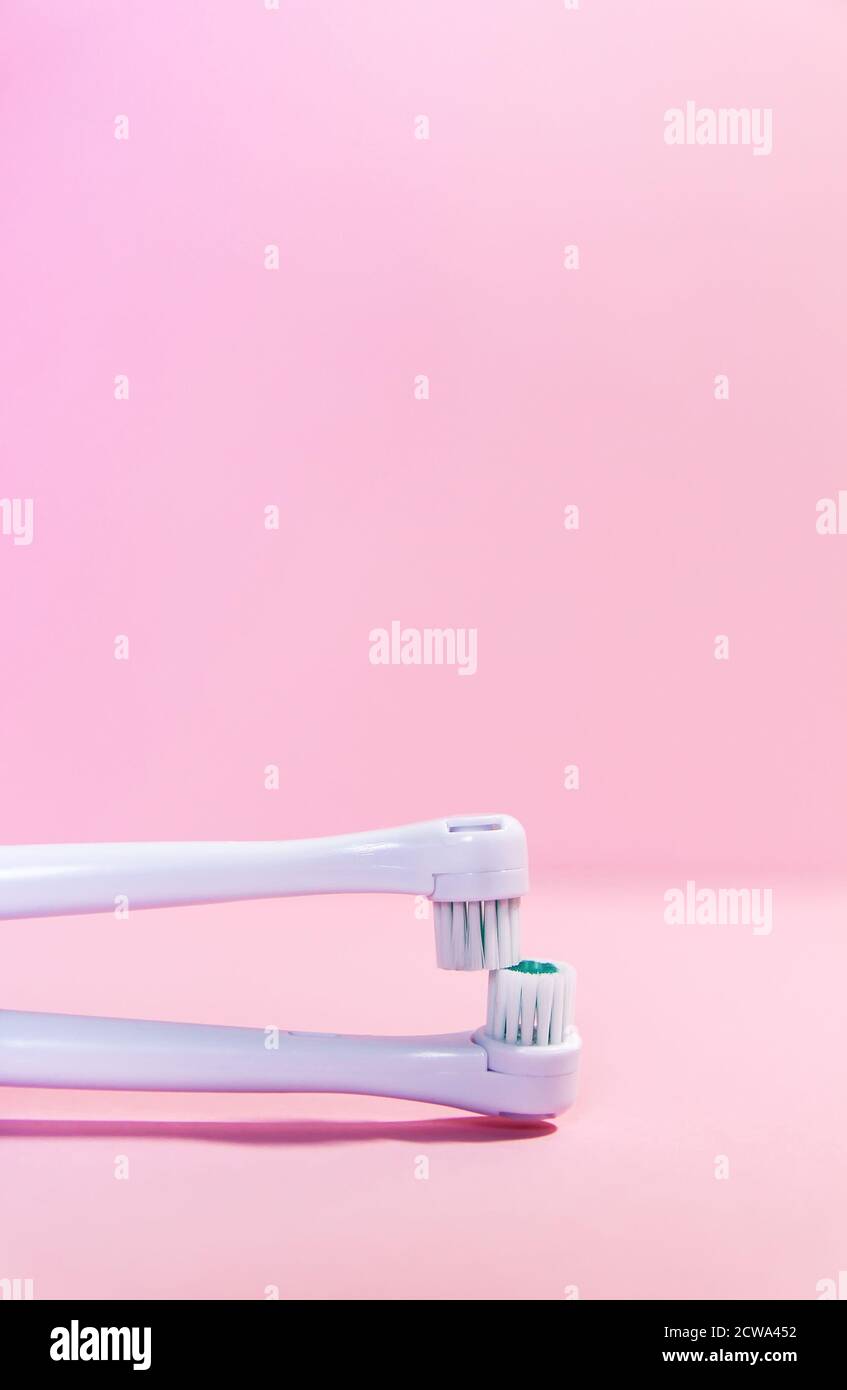Two electrical toothbrushes on a soft light pink background Stock Photo ...