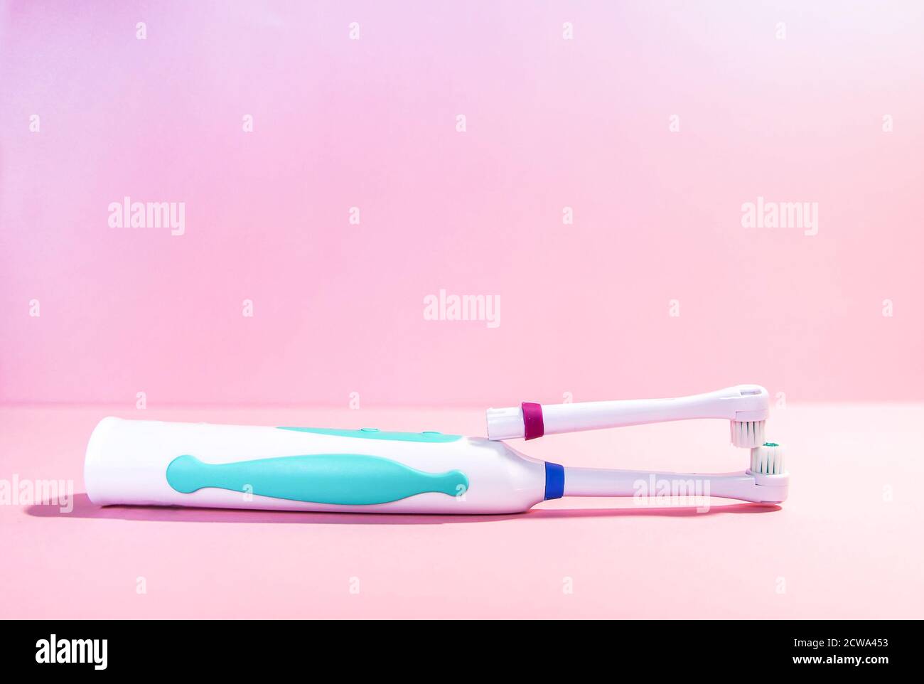 Two electrical toothbrushes on a soft light pink background Stock Photo ...