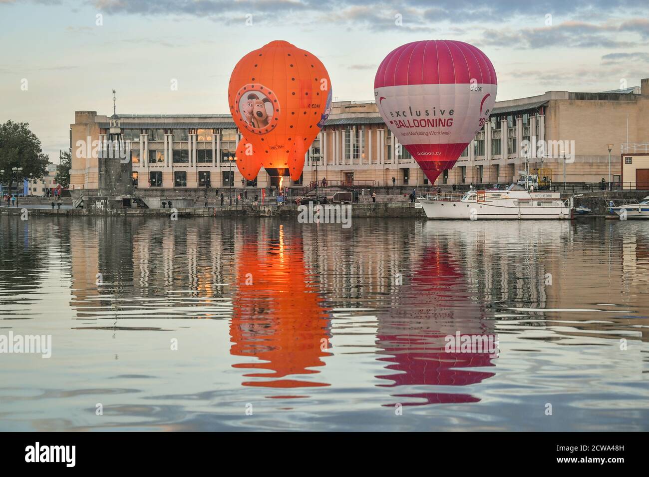 A reflection on the water during the maiden flight of a hot air balloon ...