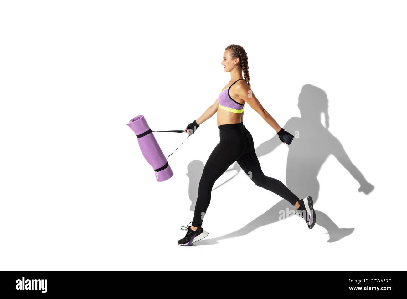 Going to work out. Beautiful young female athlete practicing on white ...