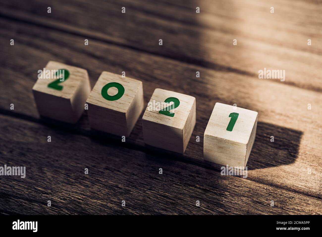 2021 happy new year on wood block on wood table and concrete wall with ...