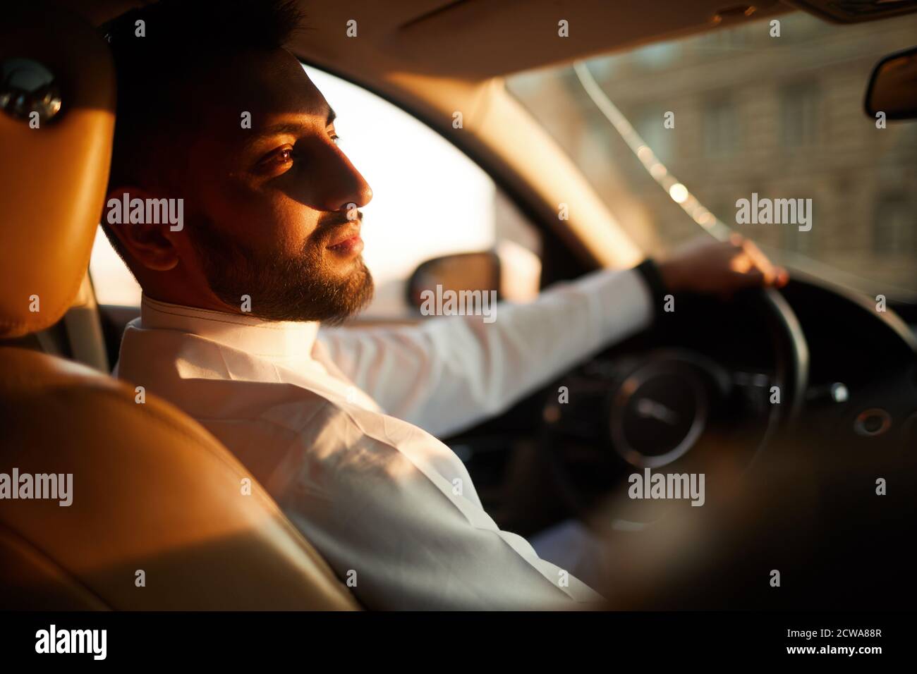 Young man sitting in the car and thinking about something during ...