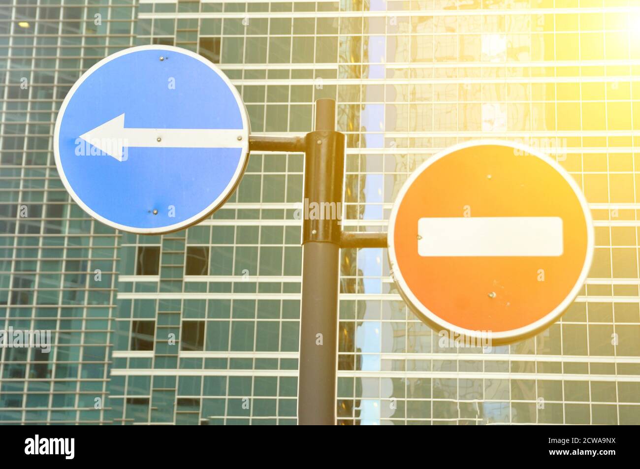 no entry and arrow to the left traffic sign in modern city surroundings ...