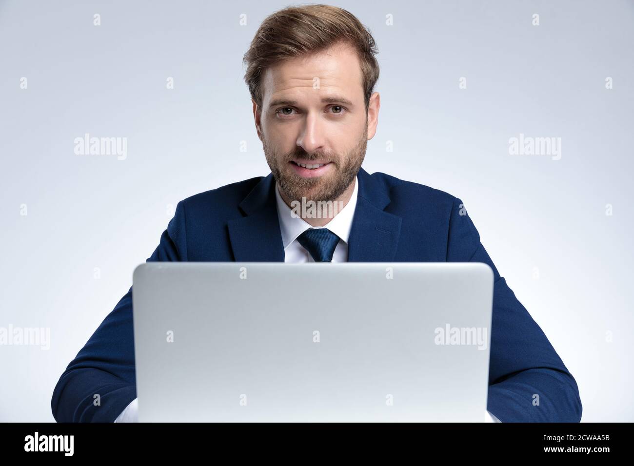 Confident businessman talking and smiling while sitting behind his ...