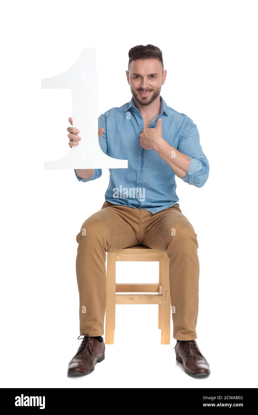 happy young man holding number one sign and pointing finger to himself ...