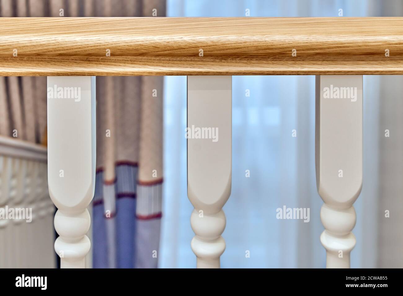 Winder steps of a wooden staircase with white balusters and pillar ...