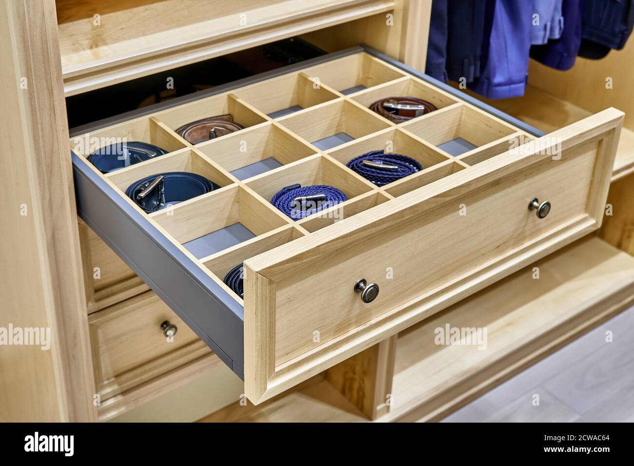 Wooden wardrobe. Open drawer with men's belts close-up Stock Photo - Alamy