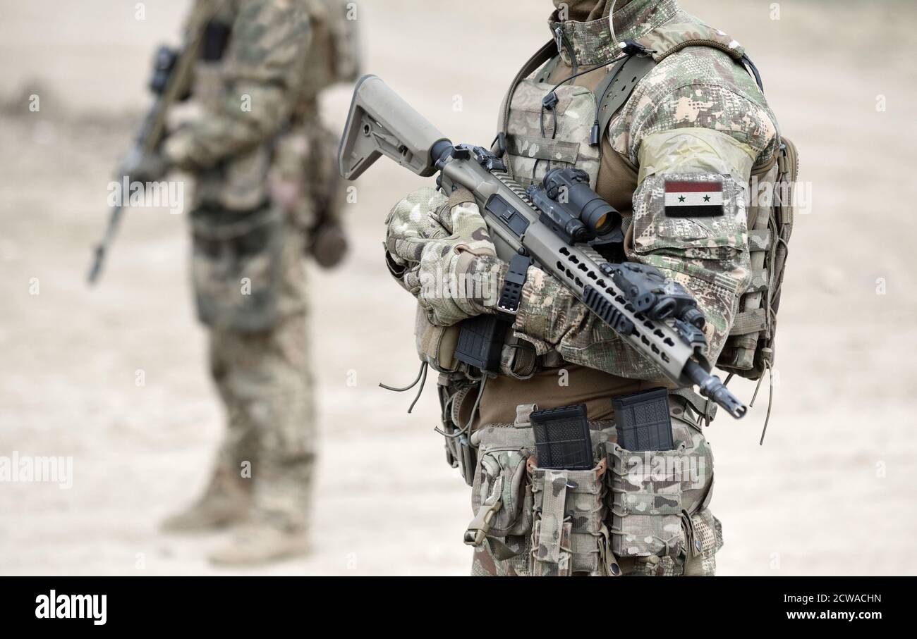 Soldiers with machine gun and flag of Syria on military uniform ...