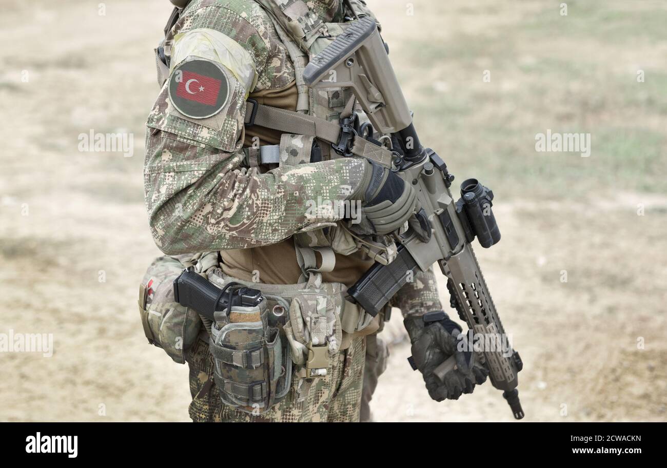 Soldier with machine gun and flag of Turkey on military uniform ...