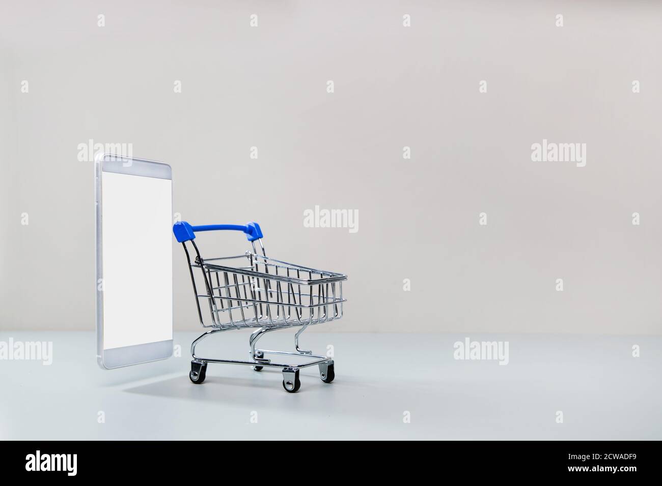 Mobile phones and mini shopping cart Stock Photo - Alamy