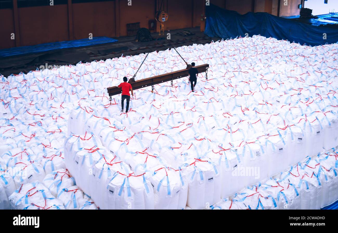 Overhead crane lift jumbo bags of tapioca using spread bar in storage ...