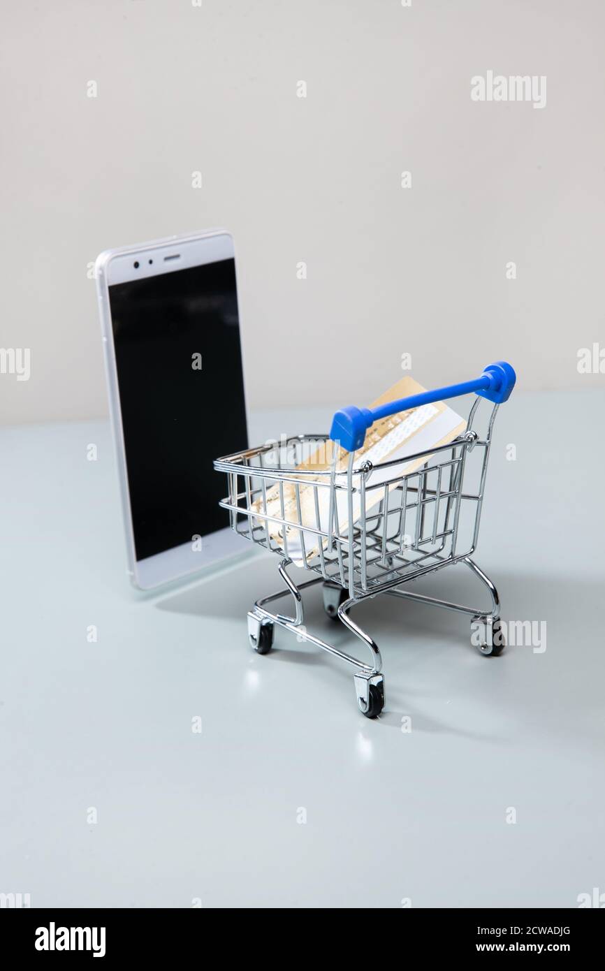 Shopping cart and mobile phone card Stock Photo - Alamy
