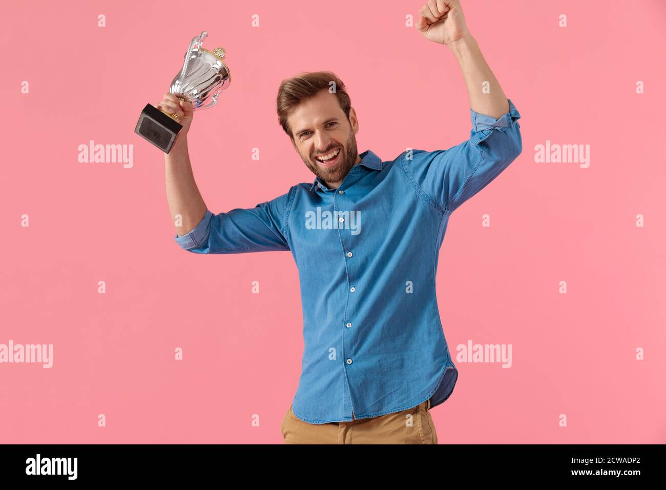 happy casual man holding trophy and celebrating victory, standing on ...
