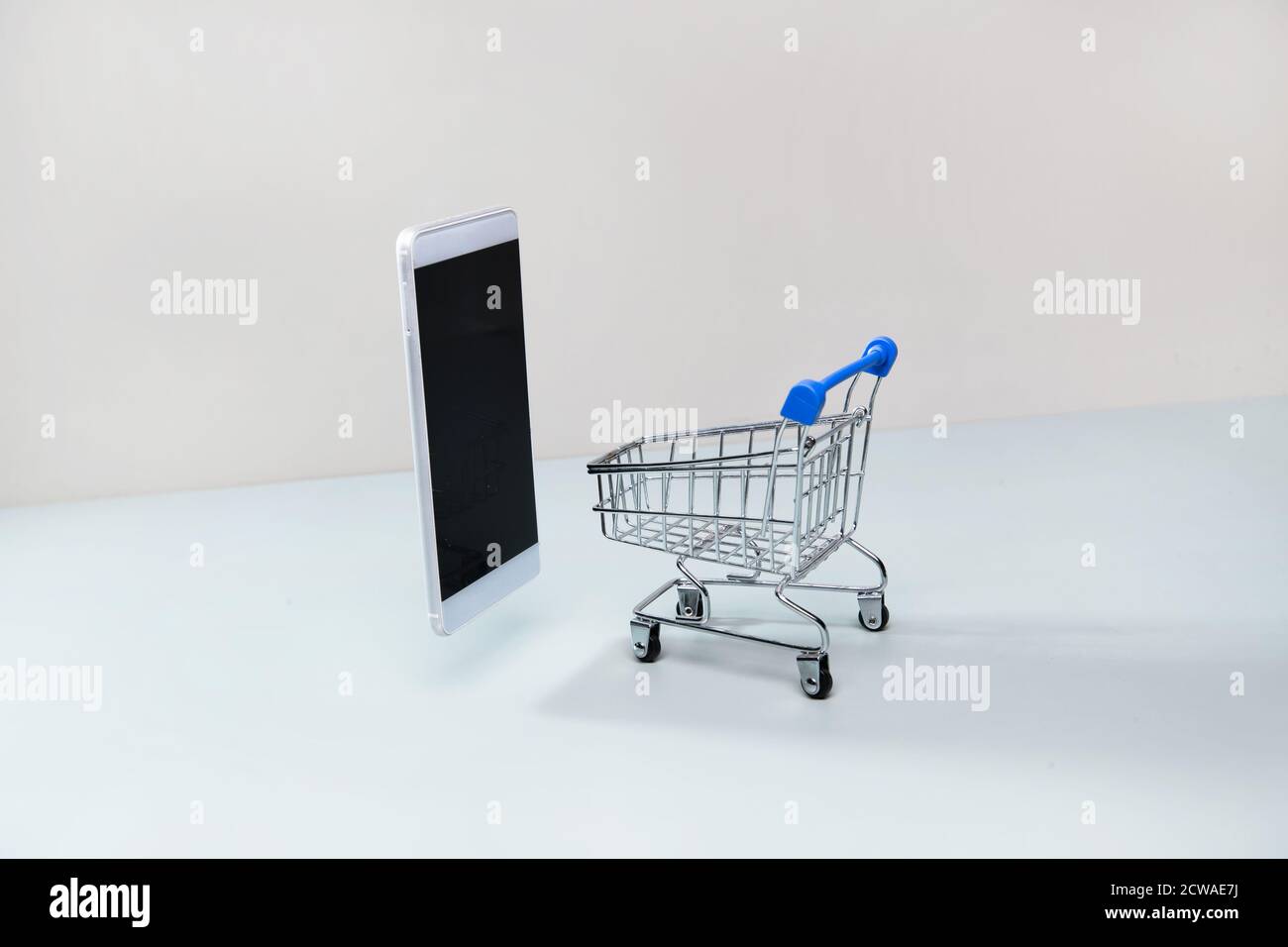 Mobile phones and mini shopping cart Stock Photo - Alamy