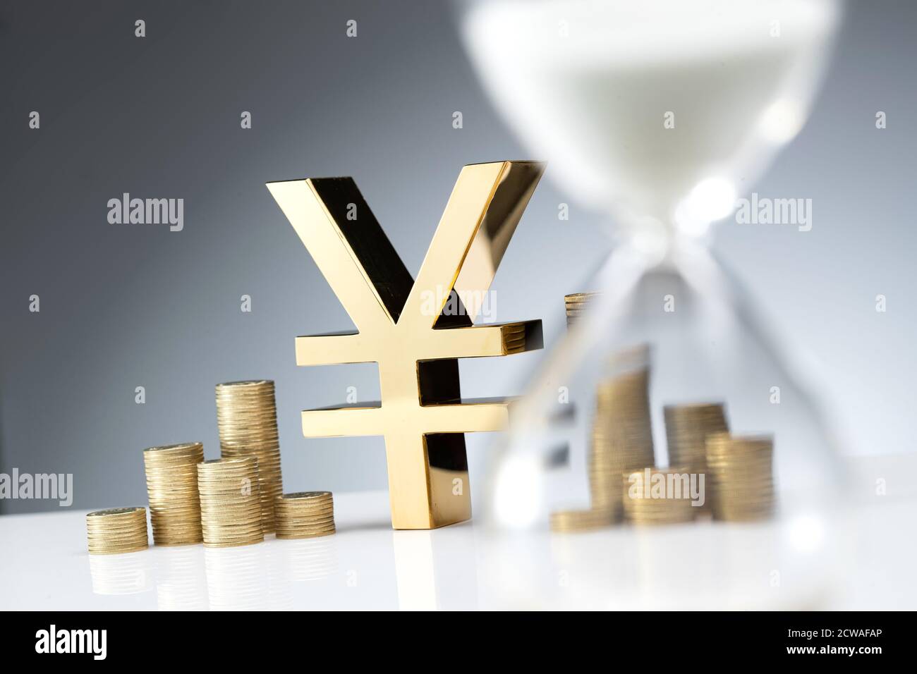 Gold currency symbol and an hourglass Stock Photo - Alamy