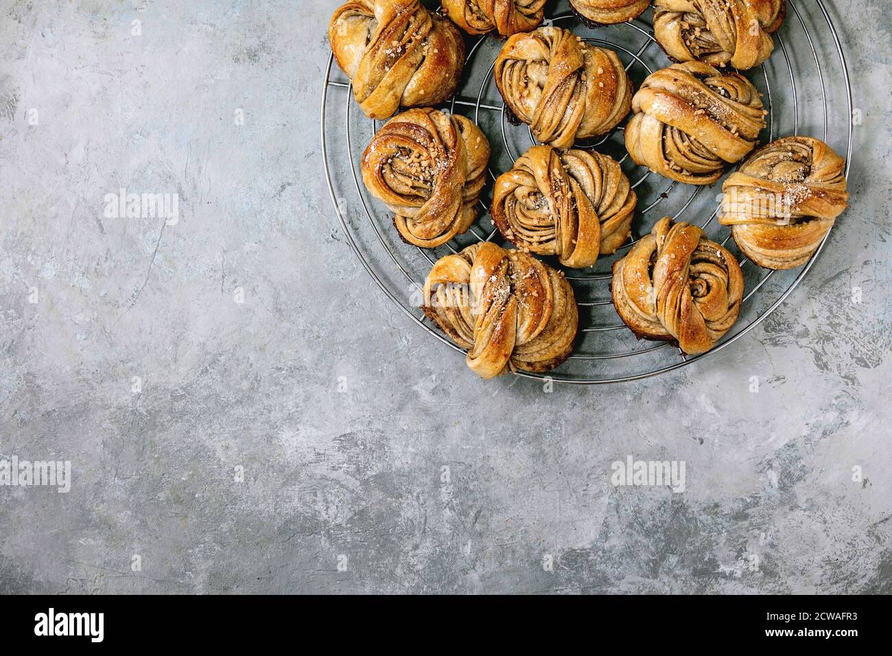 Traditional Swedish cardamom sweet buns Kanelbulle on cooling rack over ...