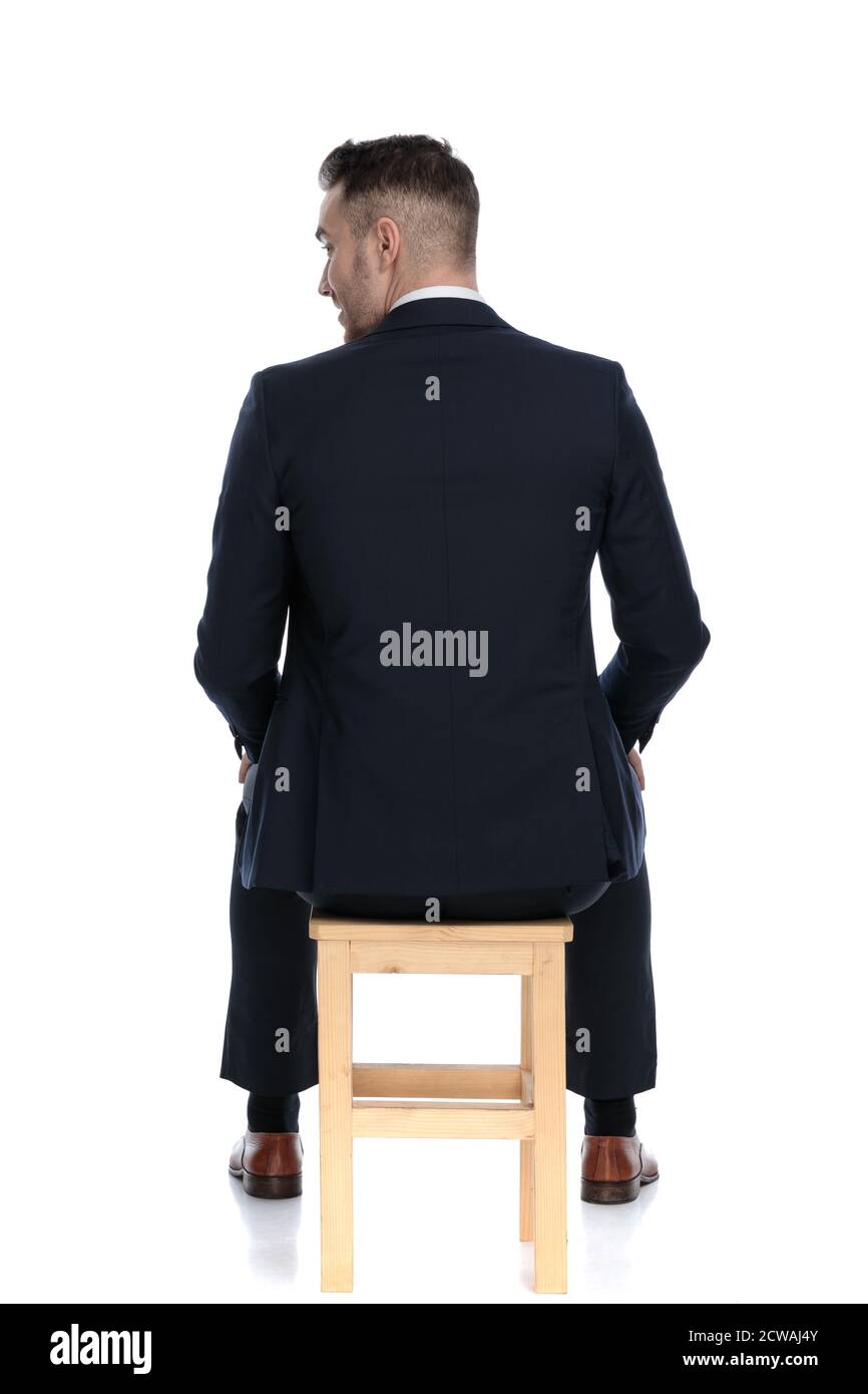 Back view of a businessman looking over his shoulder and sitting on a ...