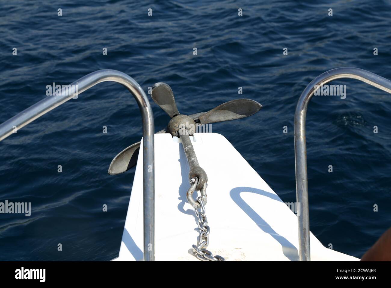 The metal anchor lies on the boat and is ready to launch Stock Photo ...