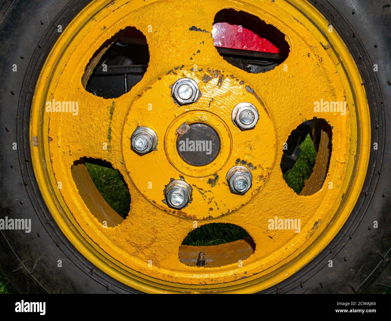 Agricultural tractor wheel with yellow disc on nuts Stock Photo - Alamy