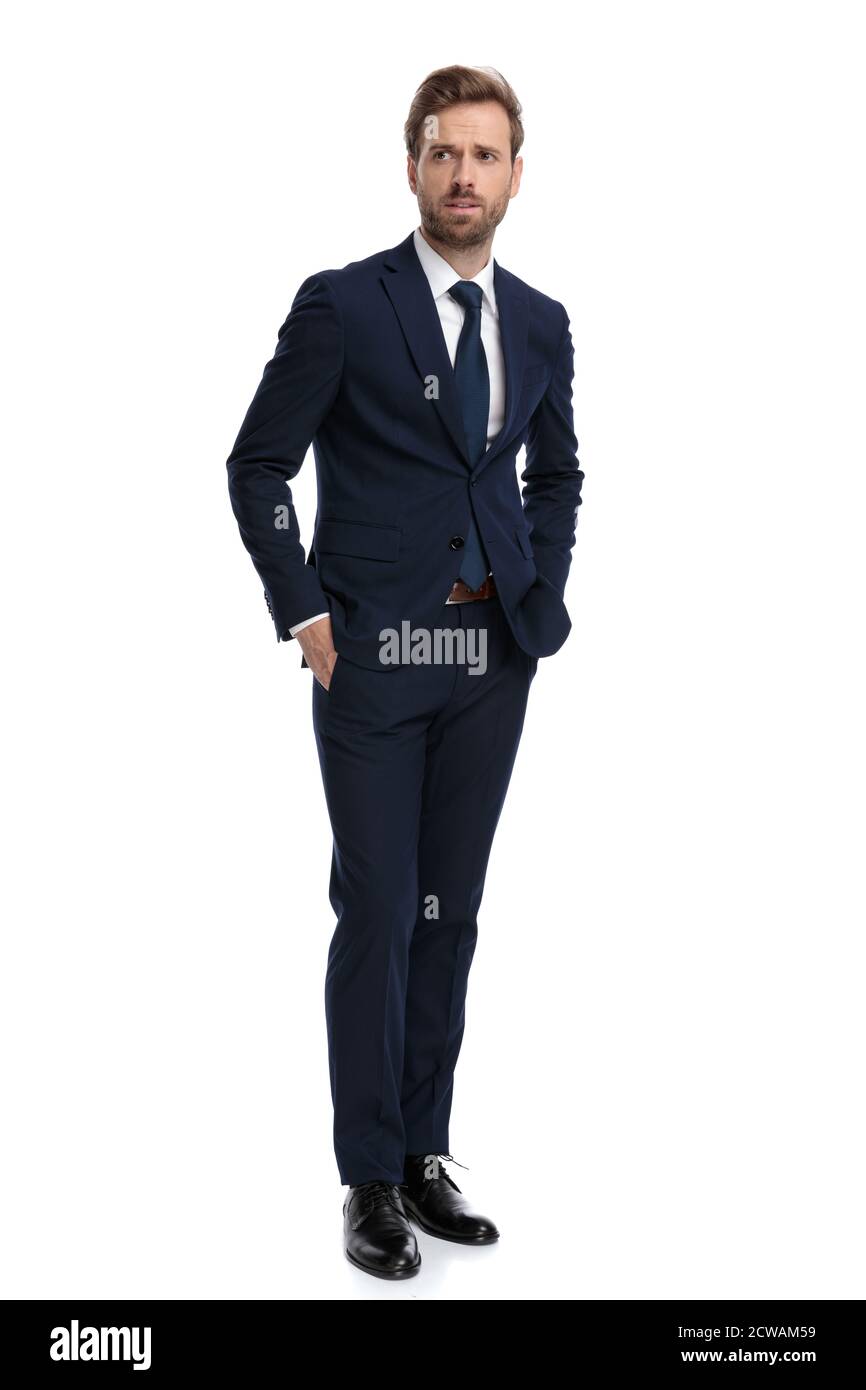 concerned young businessman in navy blue suit holding hands in pockets ...