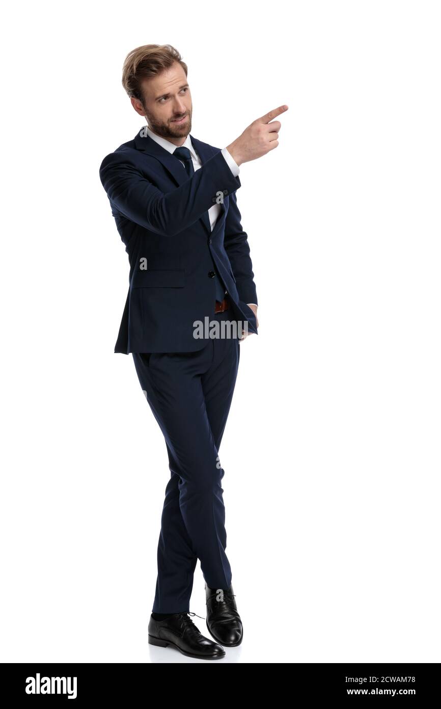 young businessman in navy blue suit pointing finger to side and showing ...
