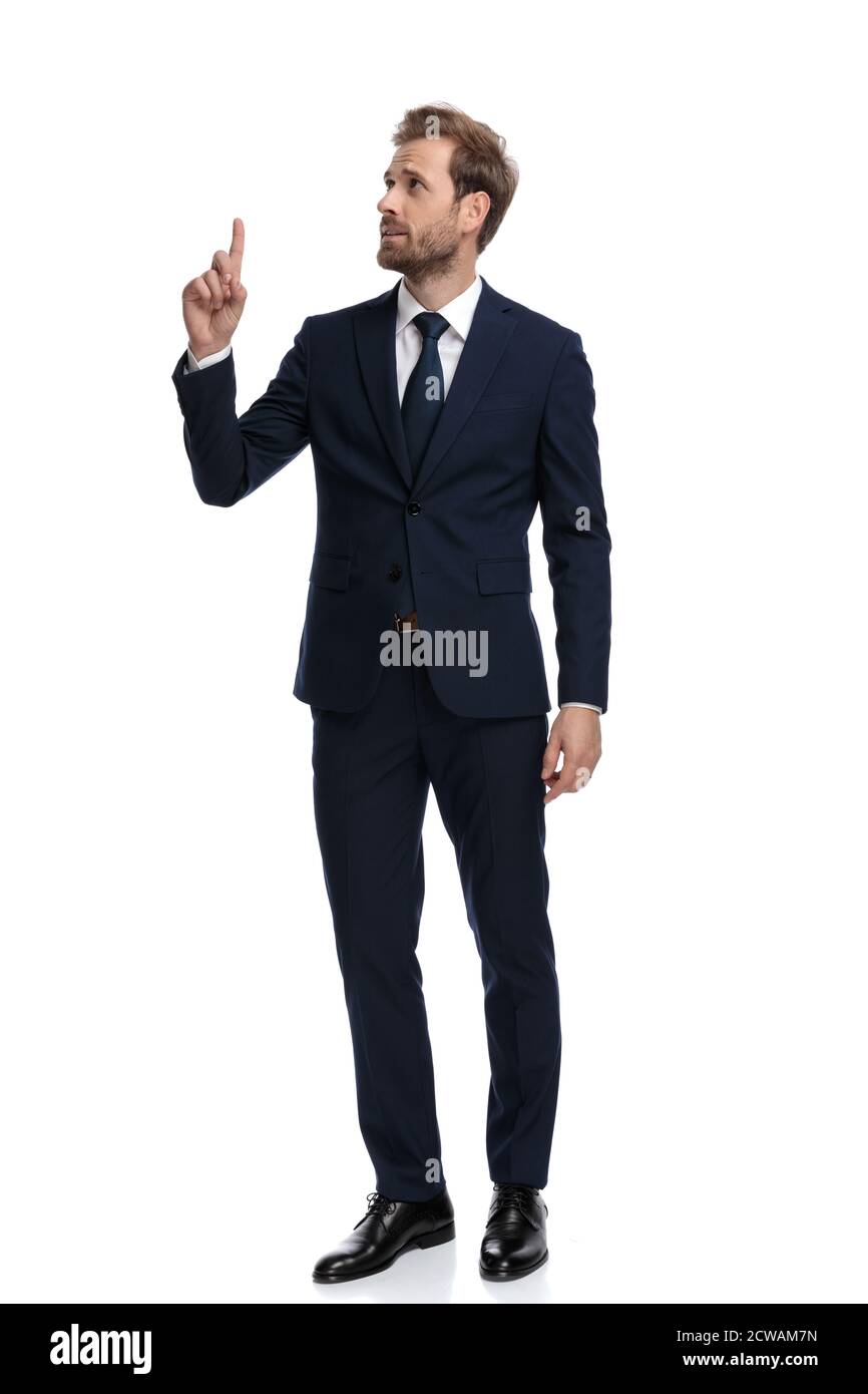 confused businessman looking up side and pointing finger, standing ...