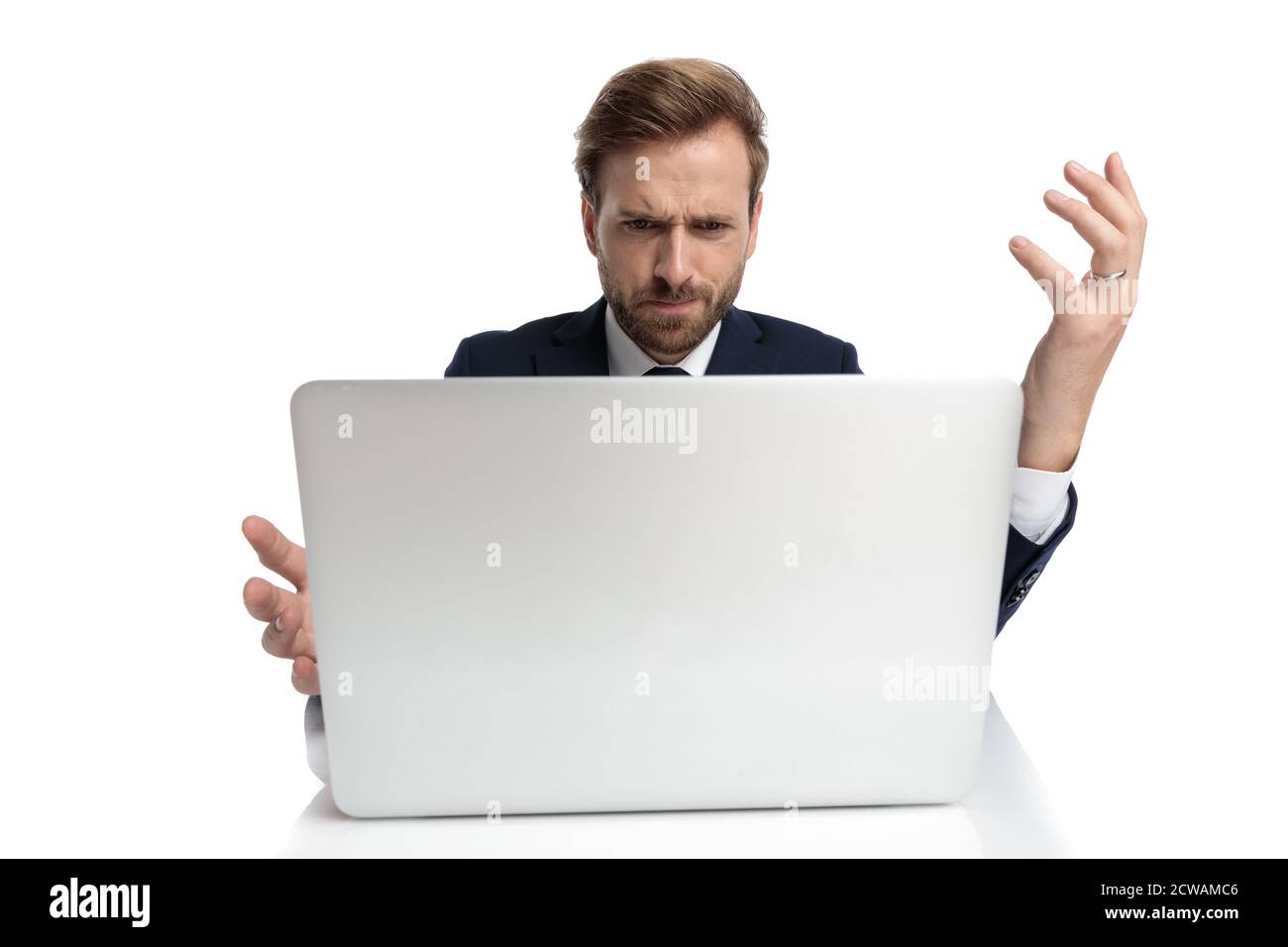 confused young businessman in navy suit reading emails, sitting ...