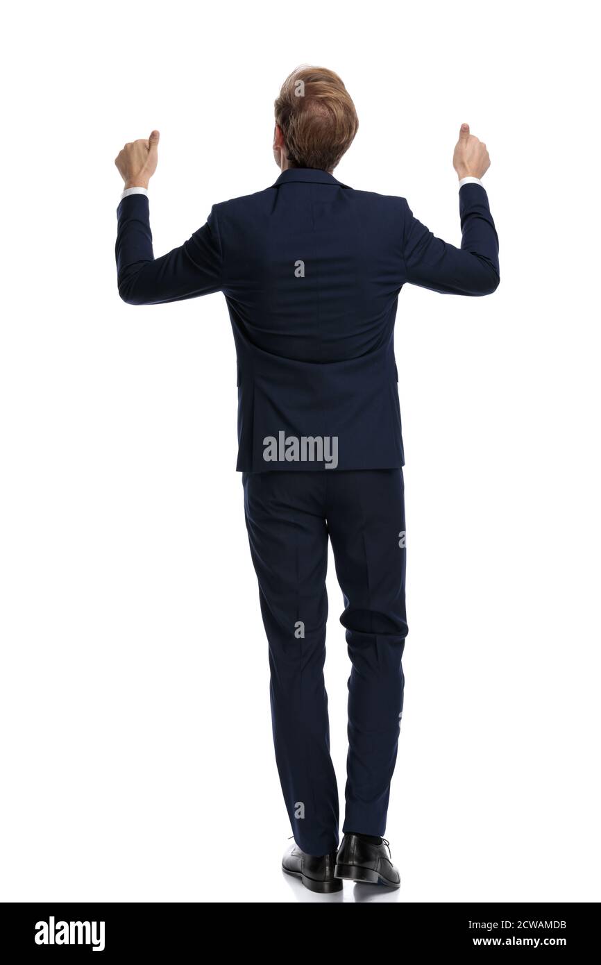businessman in navy blue suit making thumbs up sign and walking ...