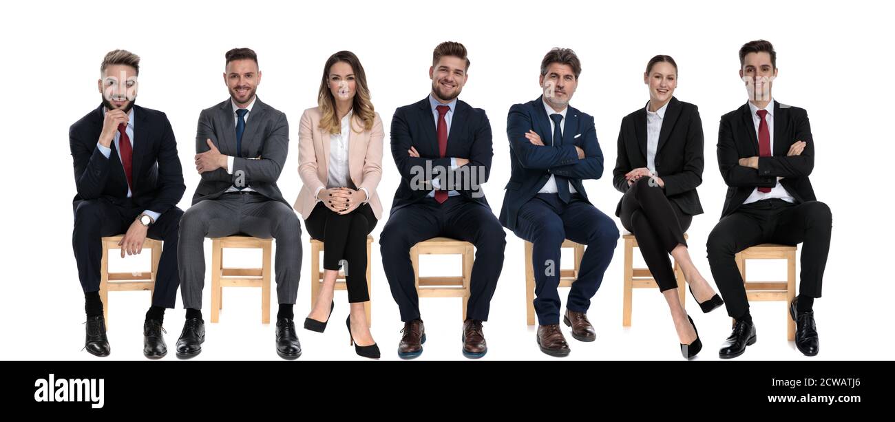 Team of 7 positive businessmen smiling with their hands crossed while ...