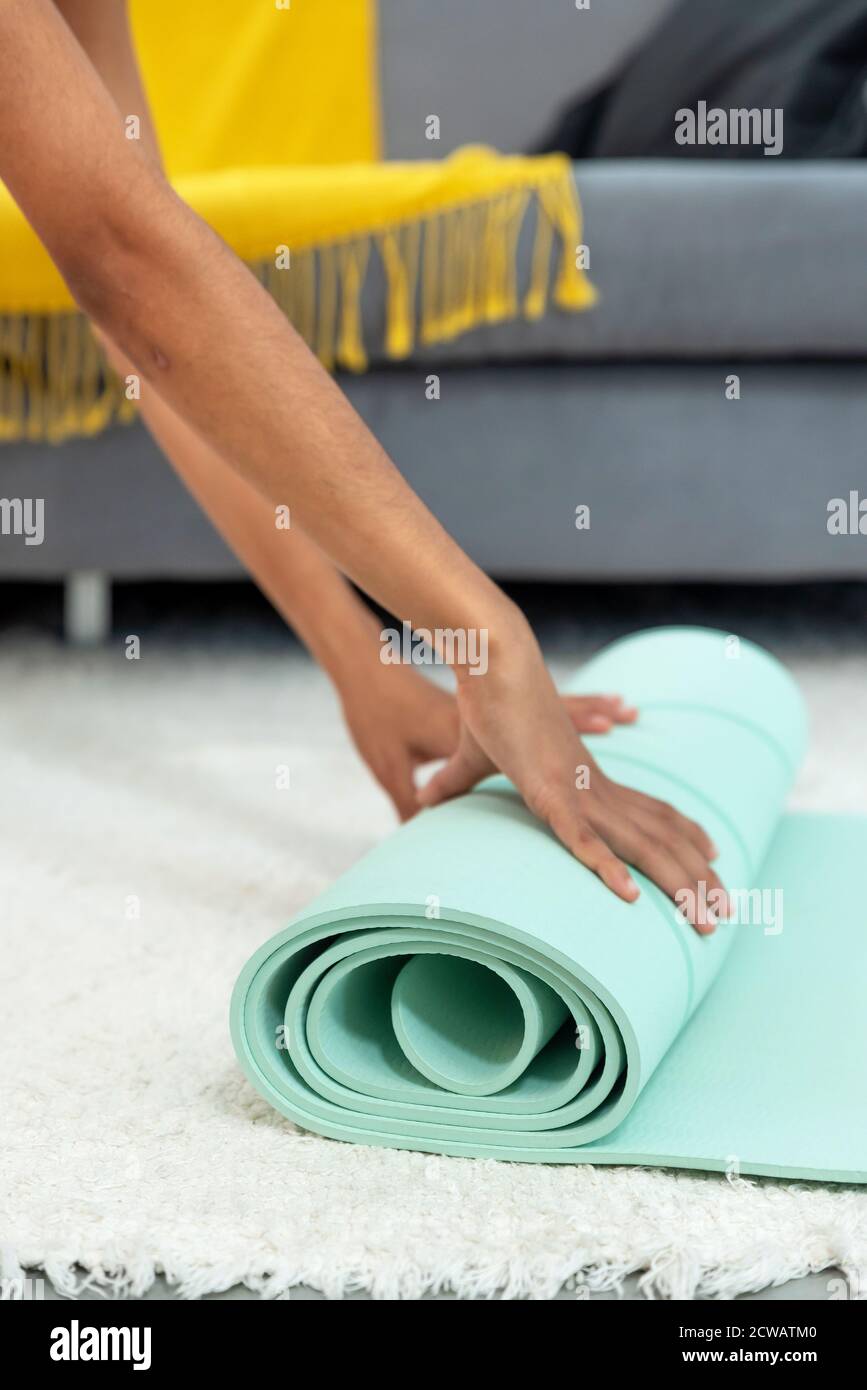 Anonymous woman unrolling her yoga mat at home Stock Photo - Alamy