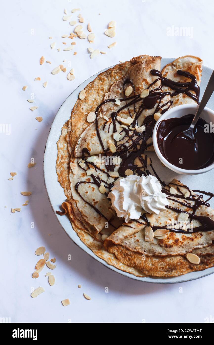 Stack of French crepes on a large plate with a drizzle of dark ...