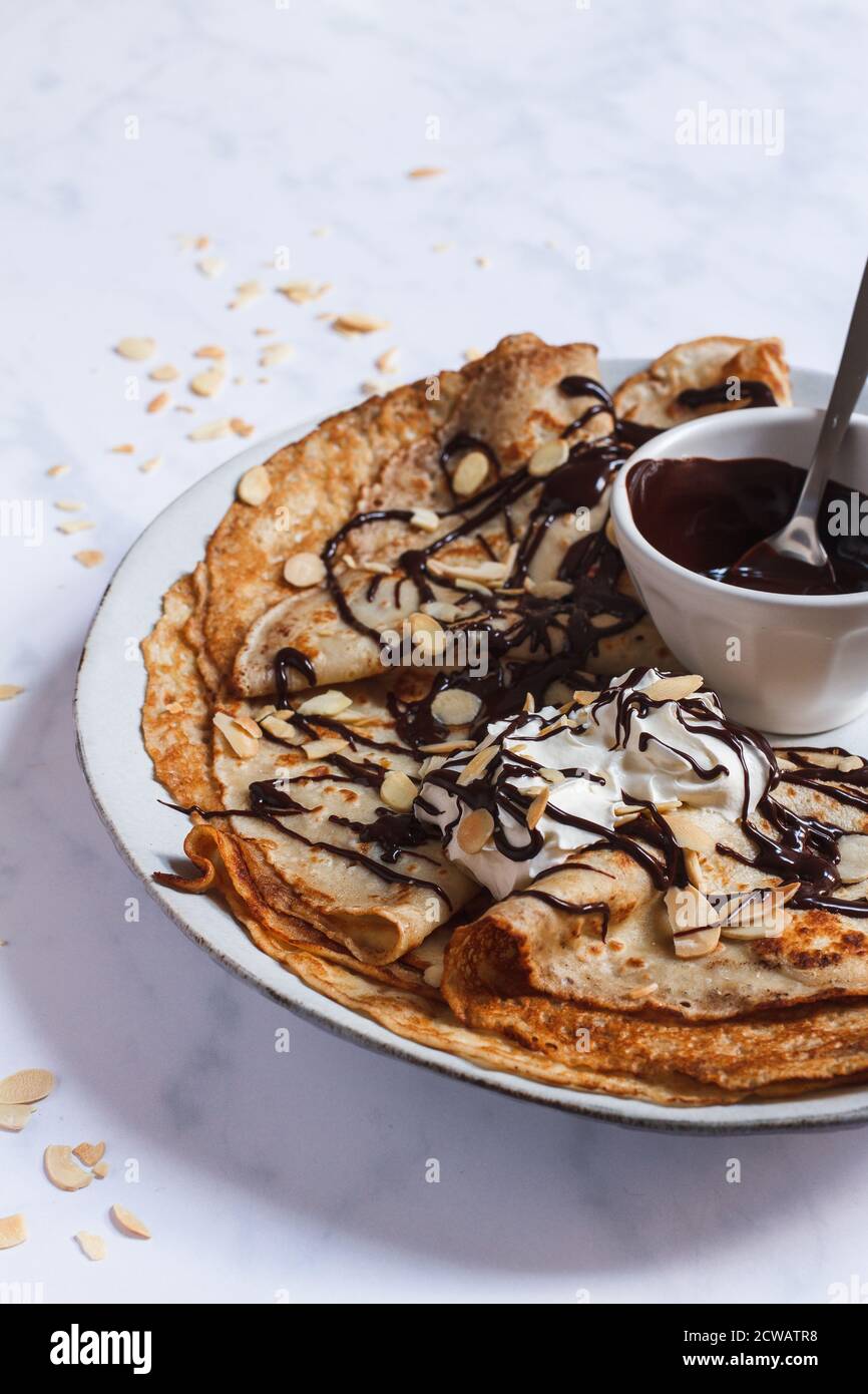 Stack of French crepes on a large plate with a drizzle of dark ...